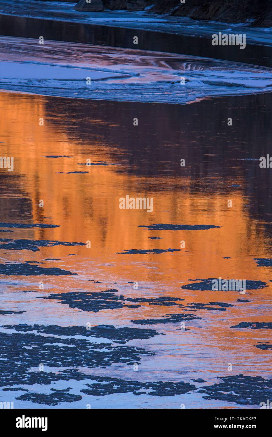 Orange sandstone cliffs reflected on the surface of the partially ...