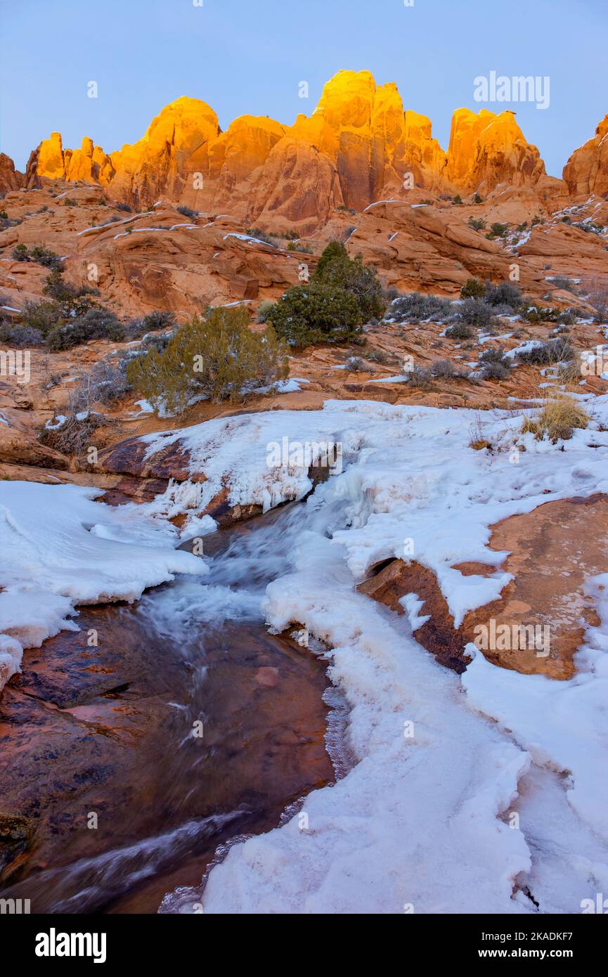 Sunset light on Entrada sandstone rock formations behind cascades on a ...