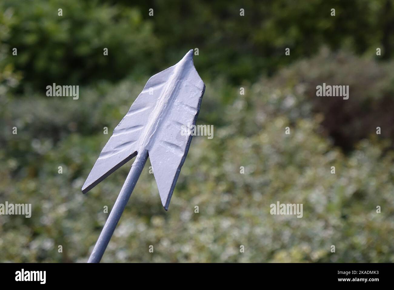 Metal arrow tip pointing right in spring, concept: target, focus, task ...
