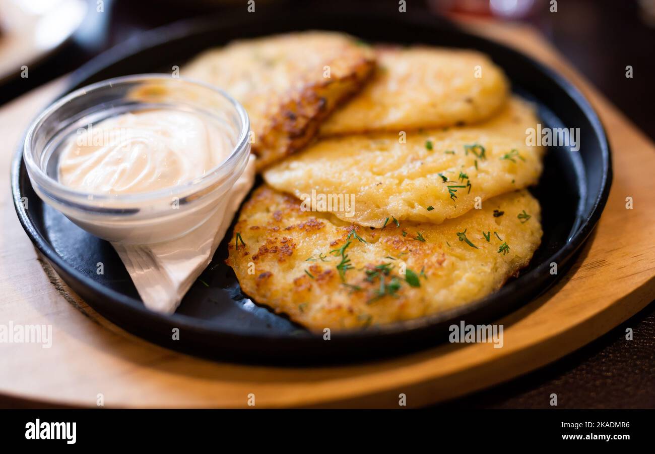 Belarusian cuisine. Potato draniki stew with sour cream Stock Photo - Alamy