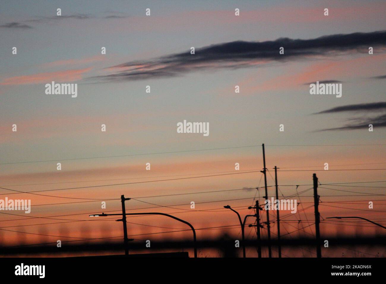 A scenic view of the sunset with electric poles and wires Stock Photo ...