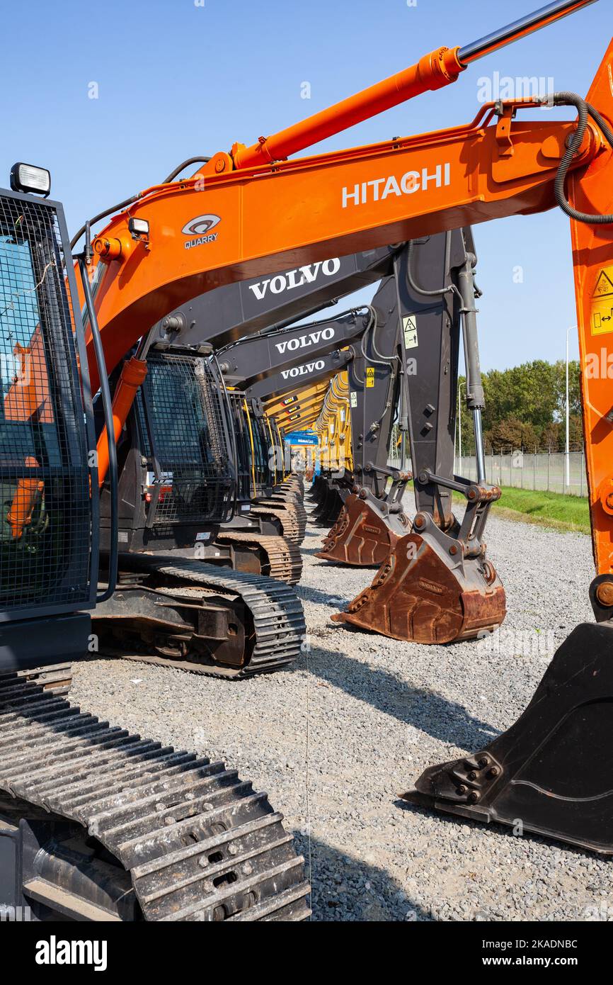 A vertical shot of a row of excavators with booms and buckets in the ...