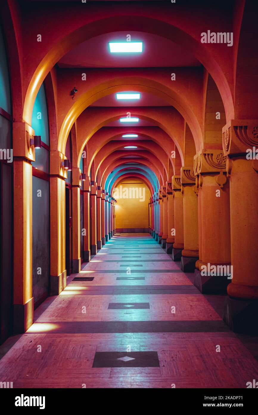 A vertical view of an illuminated arcade hall supported by columns ...