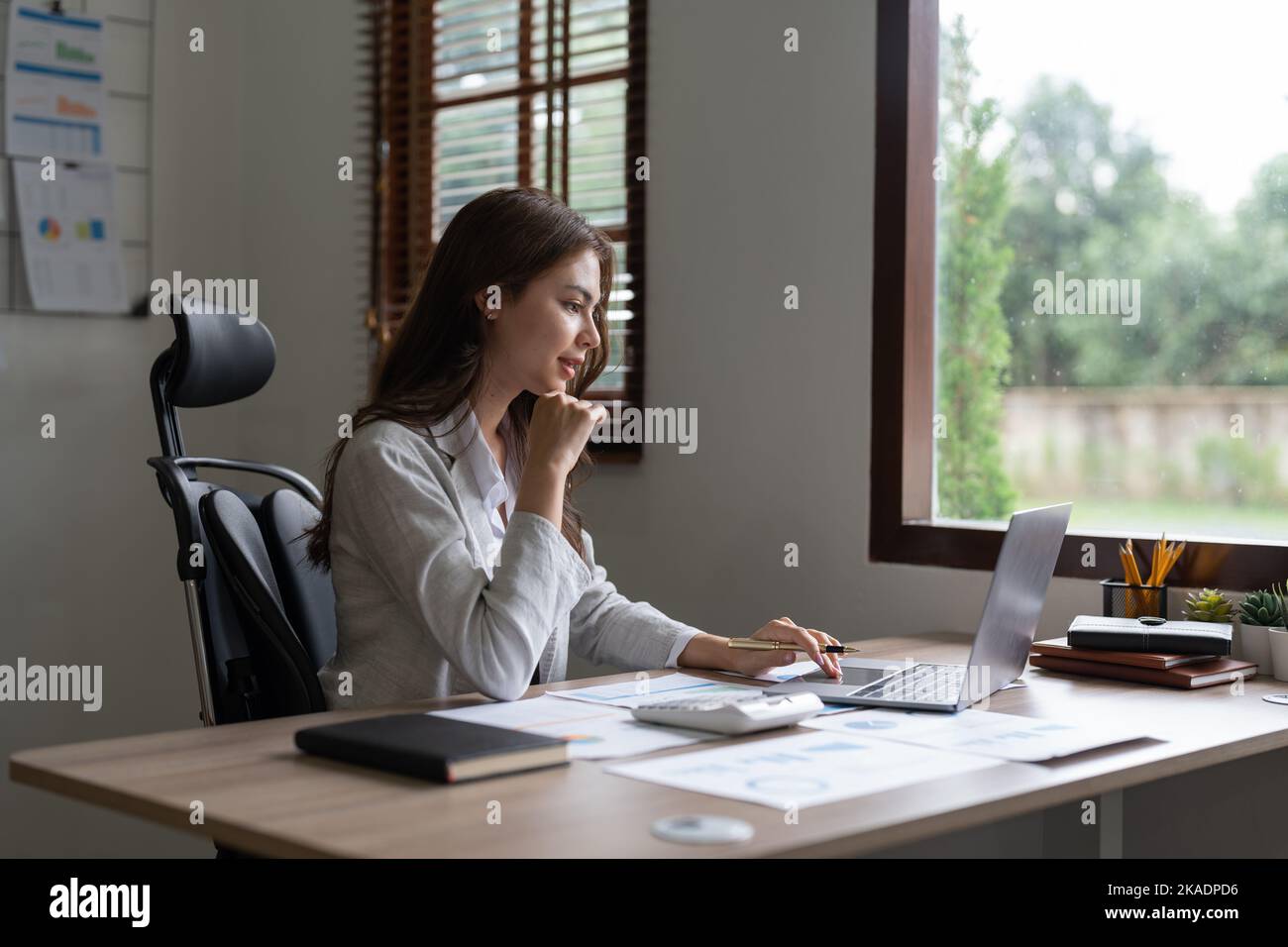Woman accountant using calculator and computer in office, finance and ...