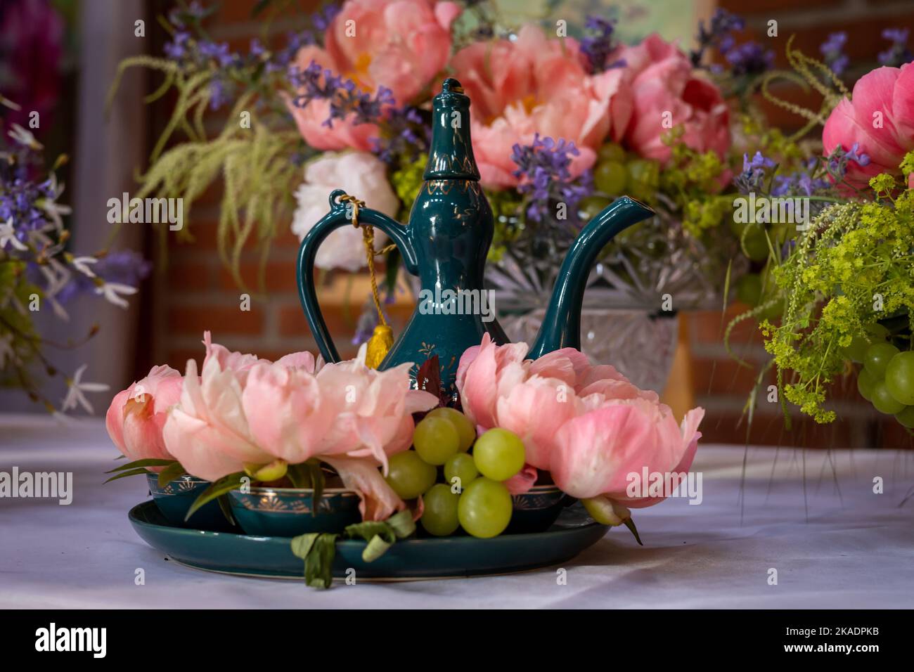 Baroque style flower arrangement with pink peony flowers, green grapes ...
