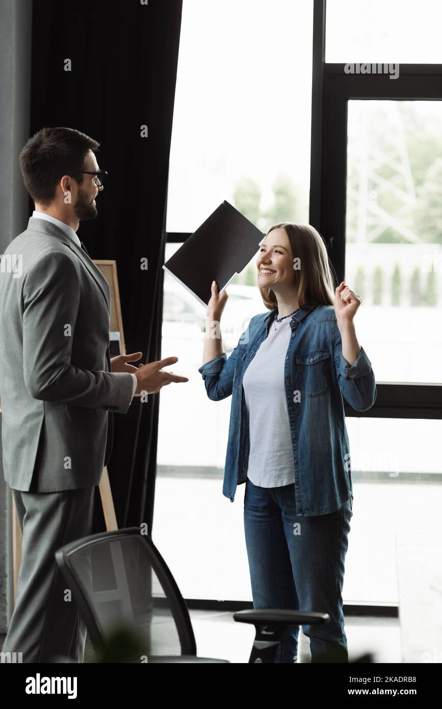 Excited woman holding resume near businessman during job interview in ...