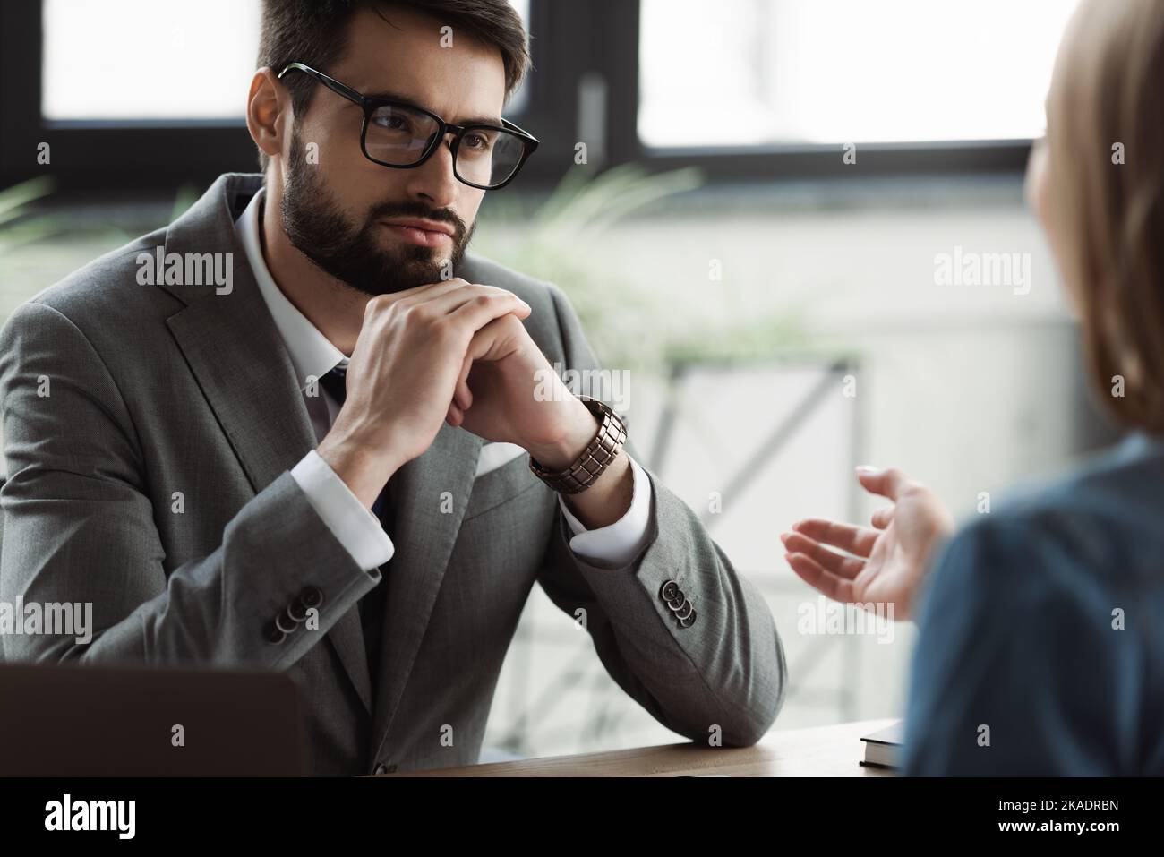 Focused businessman in suit looking at blurred candidate during job ...
