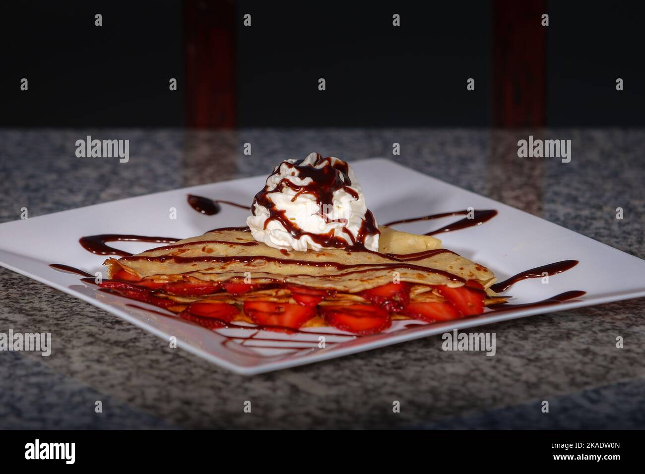 A closeup shot of ice cream with pancakes and strawberries on plate ...