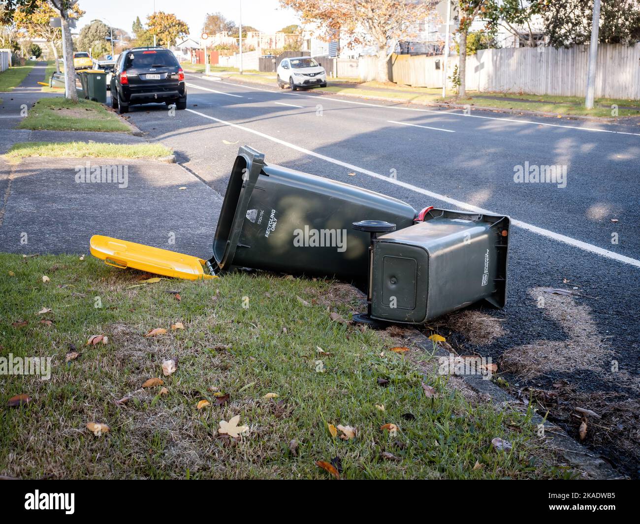 View of rubbish wheelie bins toppled by strong wind laying on ground ...