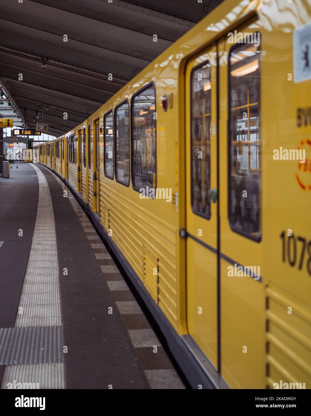 A perspective shot of a yellow train parked at the gate Stock Photo - Alamy
