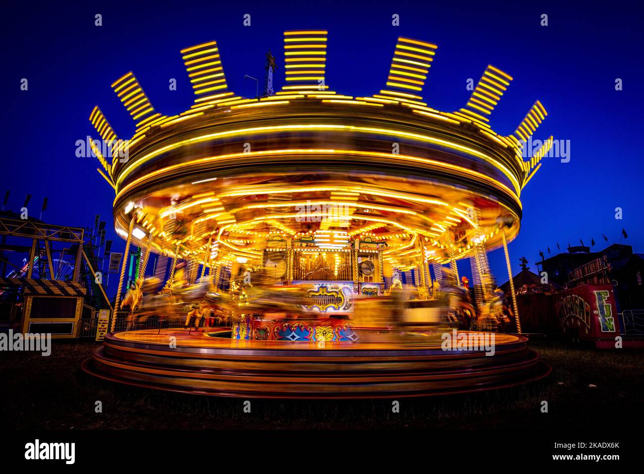 A long exposure shot of a carousel spinning with colored lights at ...