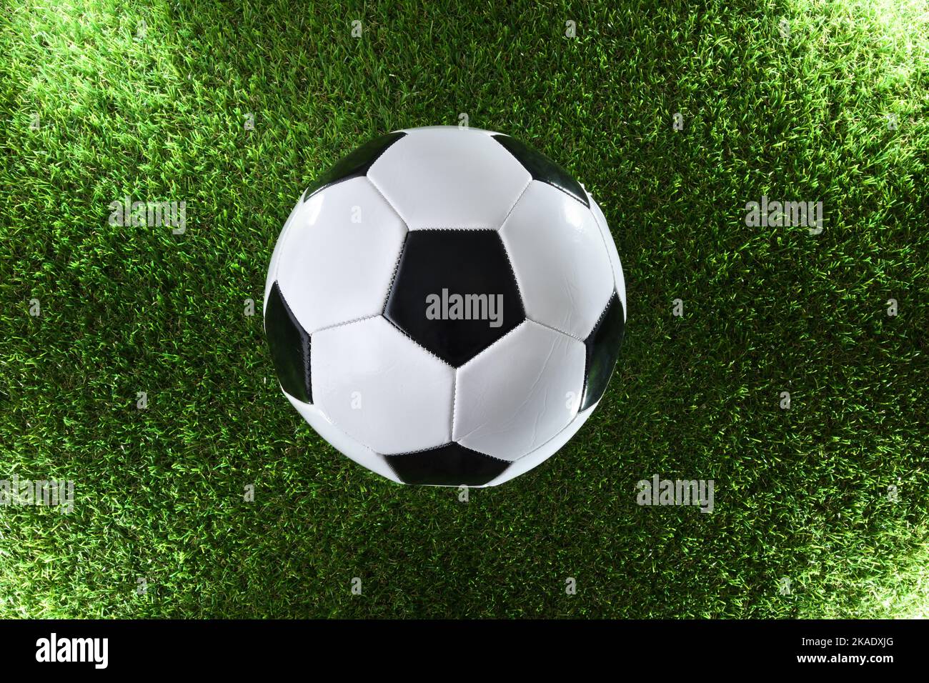 Classic soccer ball on the grass illuminated by four spotlights. Top ...
