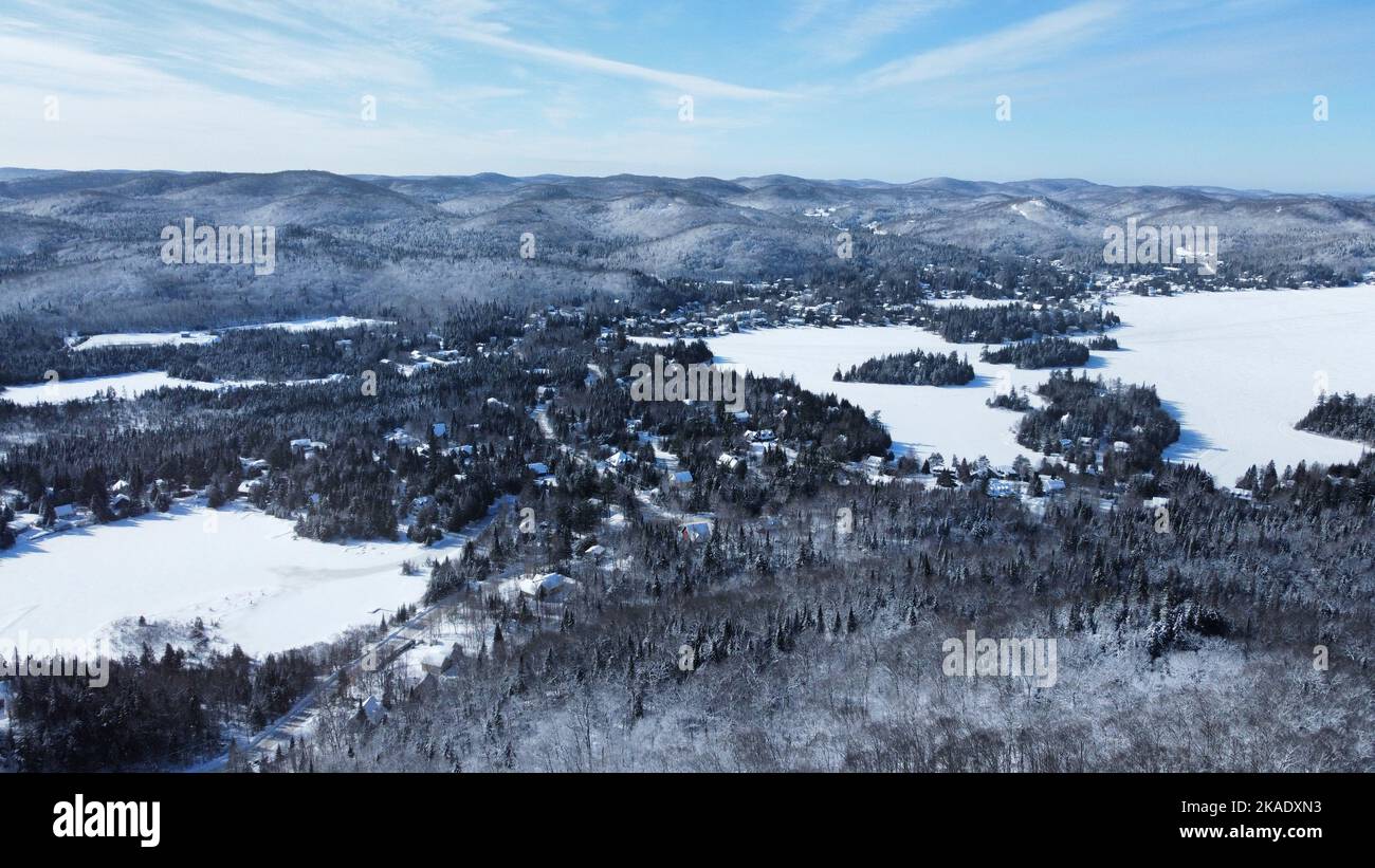 An aerial view of a landscape with forest and fields covered in snow ...