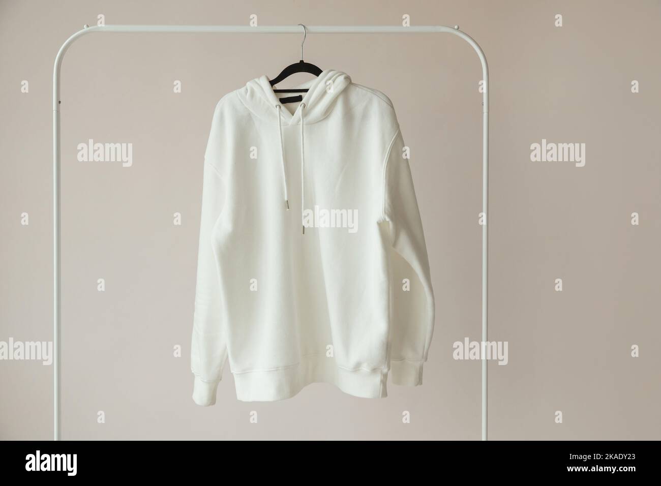Blank White Hoodie, Sweatshirt Mock-up hanging on white Rack Hanger ...