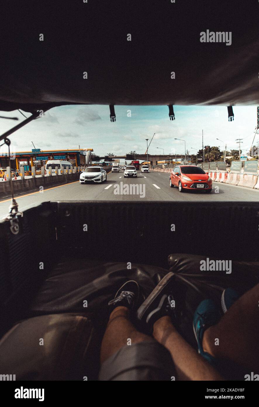The legs of persons in a car's back on Highway Bangkok Thailand ...
