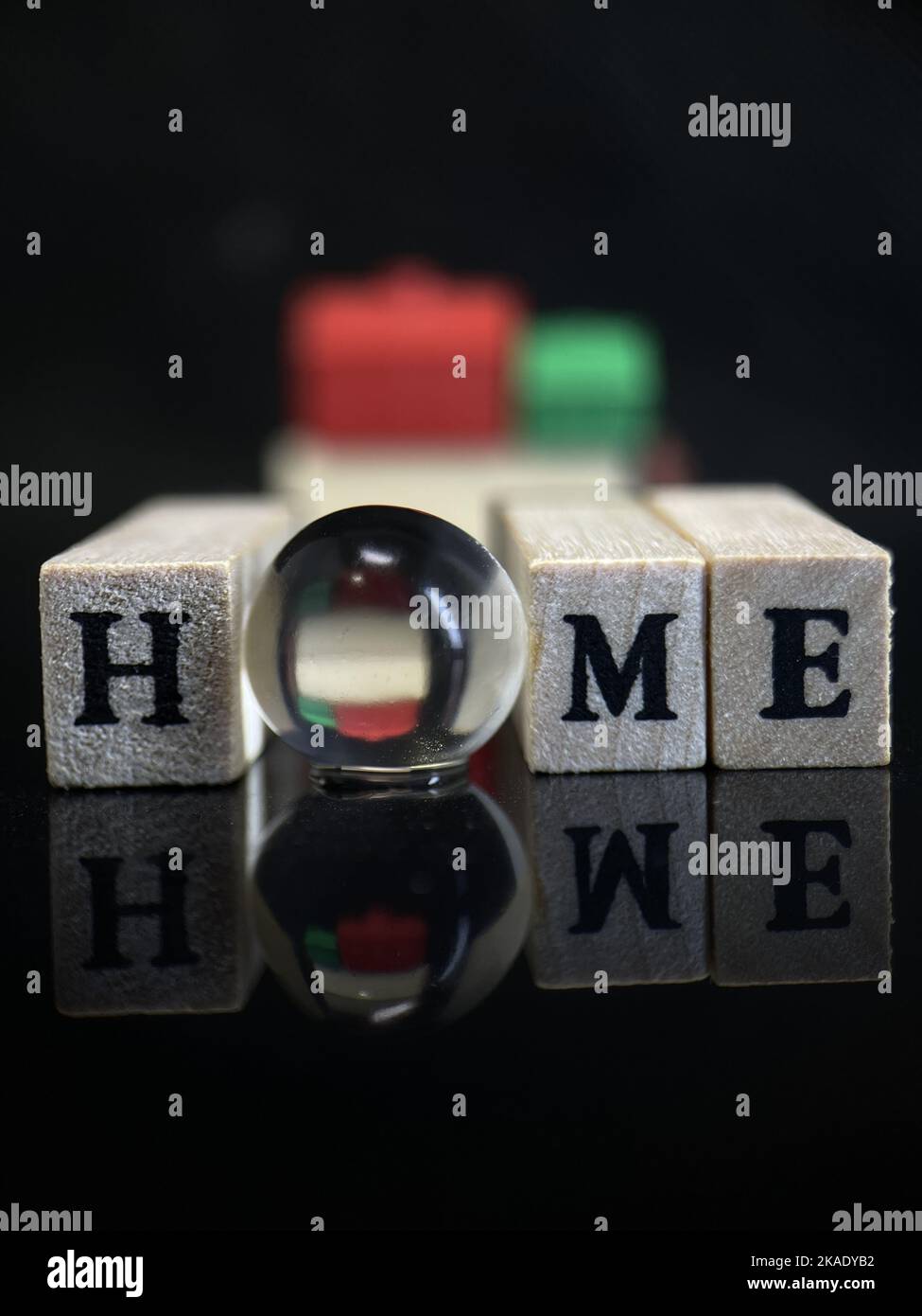 The word home is isolated in a dark background. Red and green plastic ...