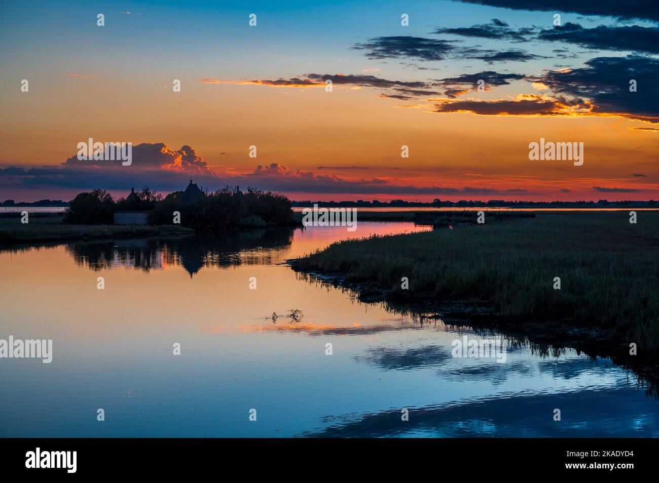 Towards the sunset. Marano lagoon late summer colors. Clouds and sun ...