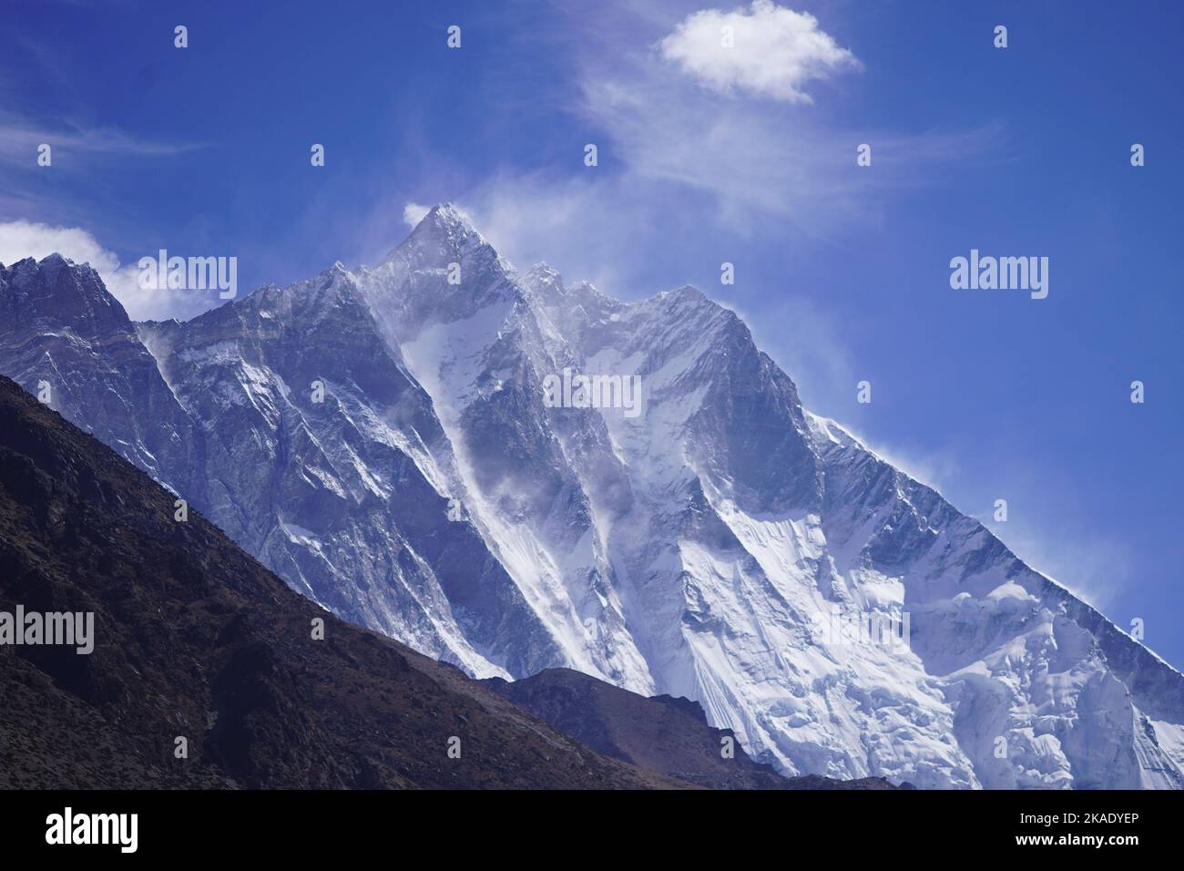 A scenic view of Lhotse mountain in Asia covered in snow in blue sky ...