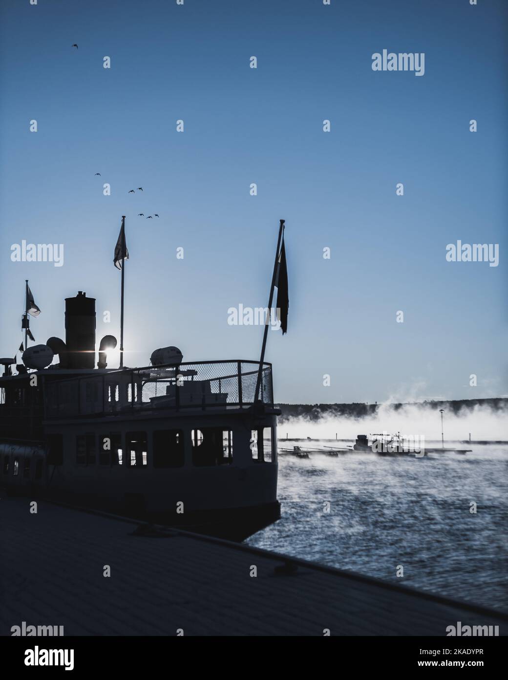 A beautiful shot of a yachy with flags by the dock with splashing water ...