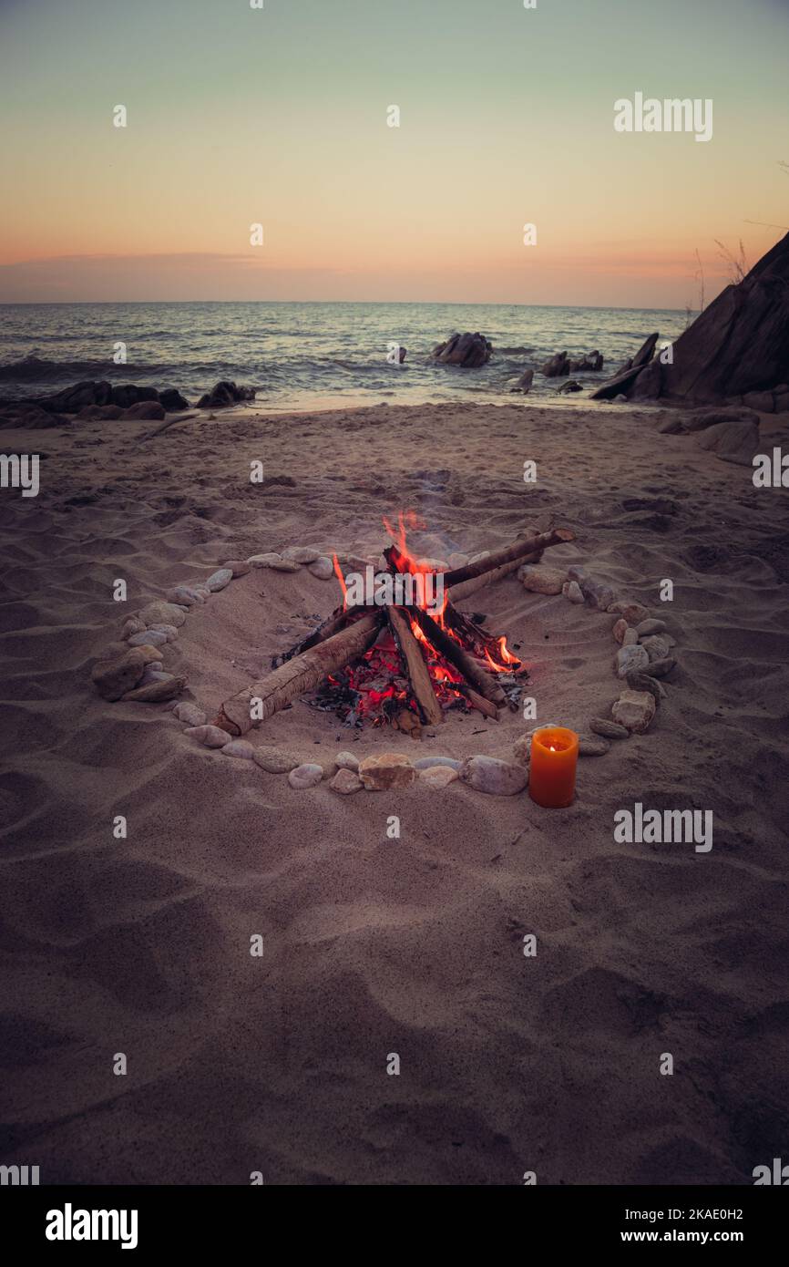 A bonfire on a sandy beach with a beautiful sunset background Stock ...
