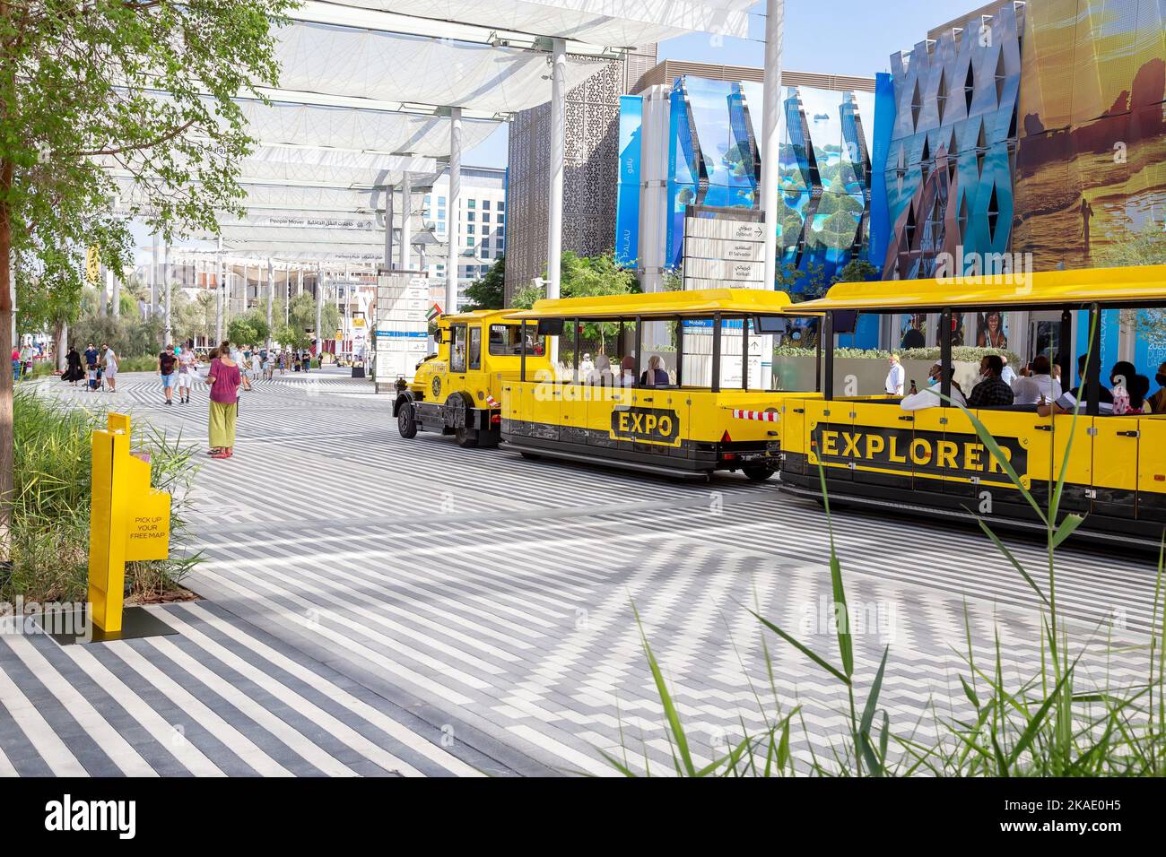 yellow electric train carrying people Stock Photo - Alamy