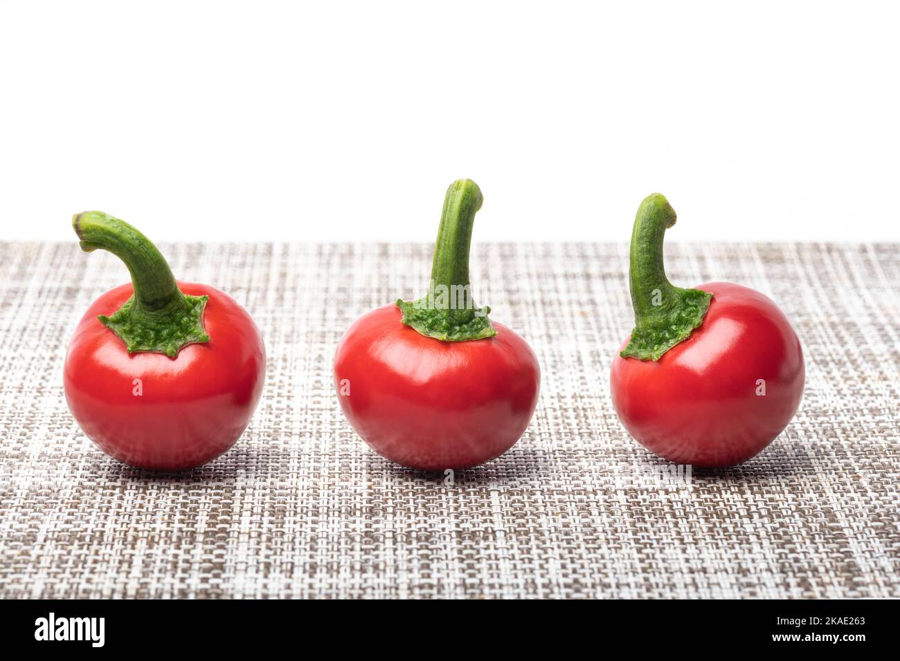 Bright ripe round red chili peppers cuts and seeds on cloth isolated ...