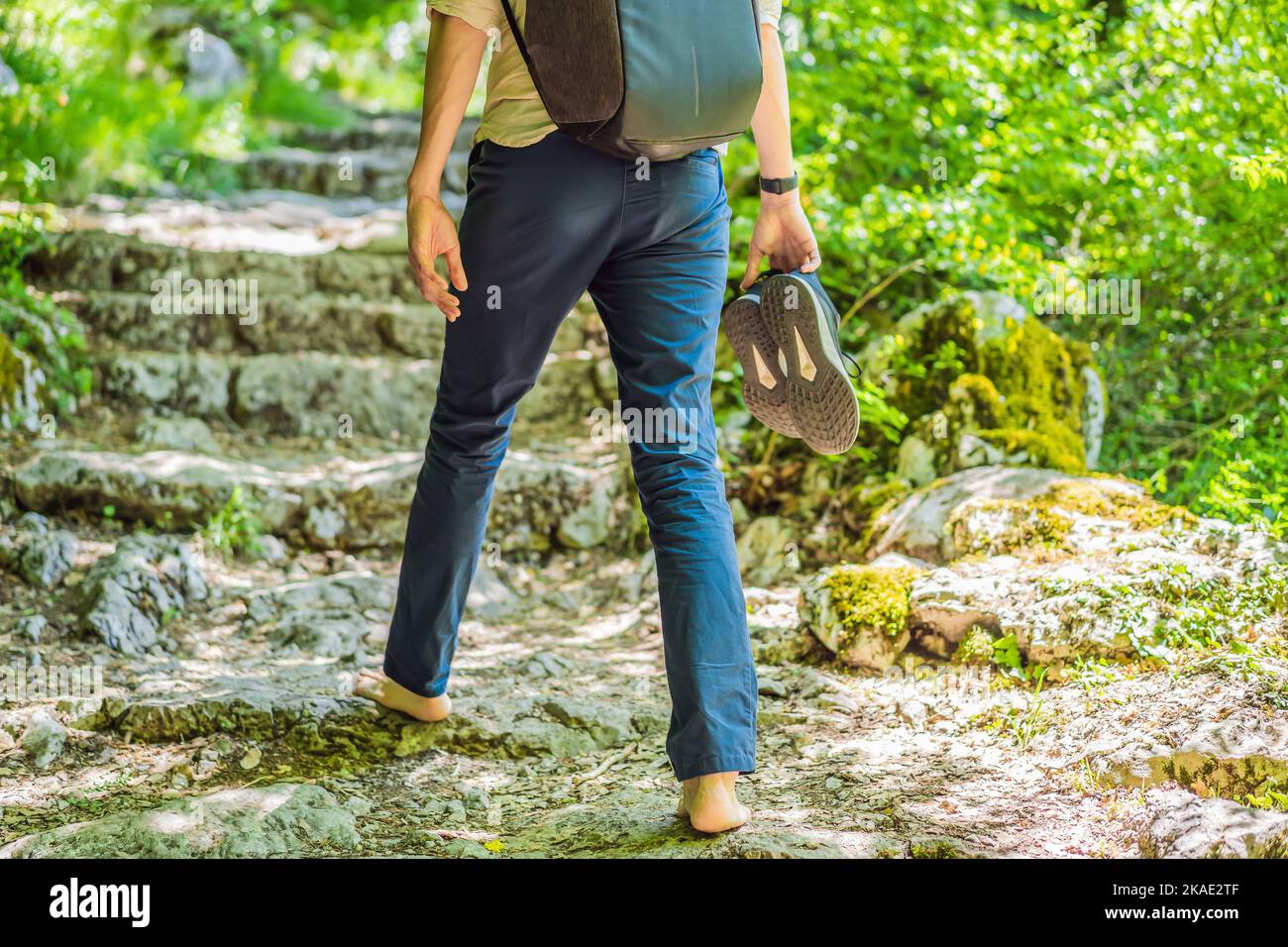 Man tourist climb barefoot the mountain to the Ostrog. It is a ...