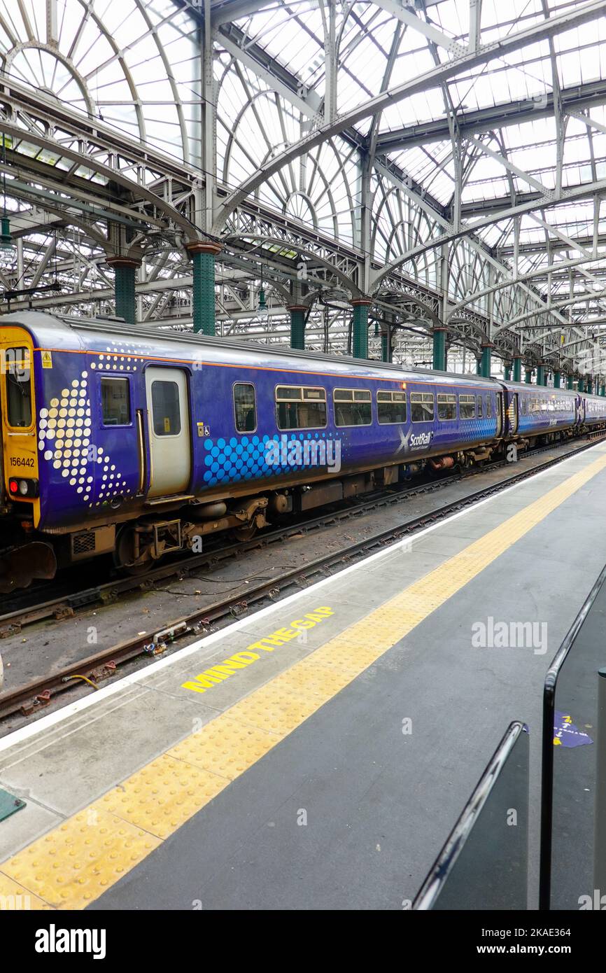 ScotRail train at station platform. "Mind the Gap" written on platform ...