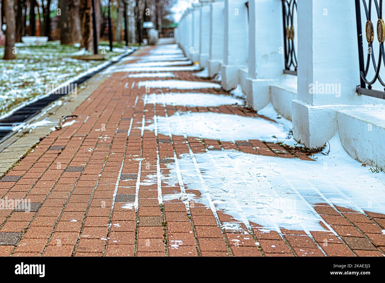 Paving paths in the park, covered with the first snow in winter. Winter ...