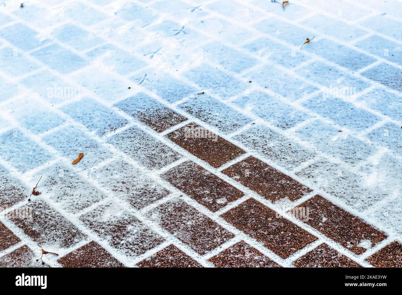 The texture of the cobblestone path covered with the first snow in ...