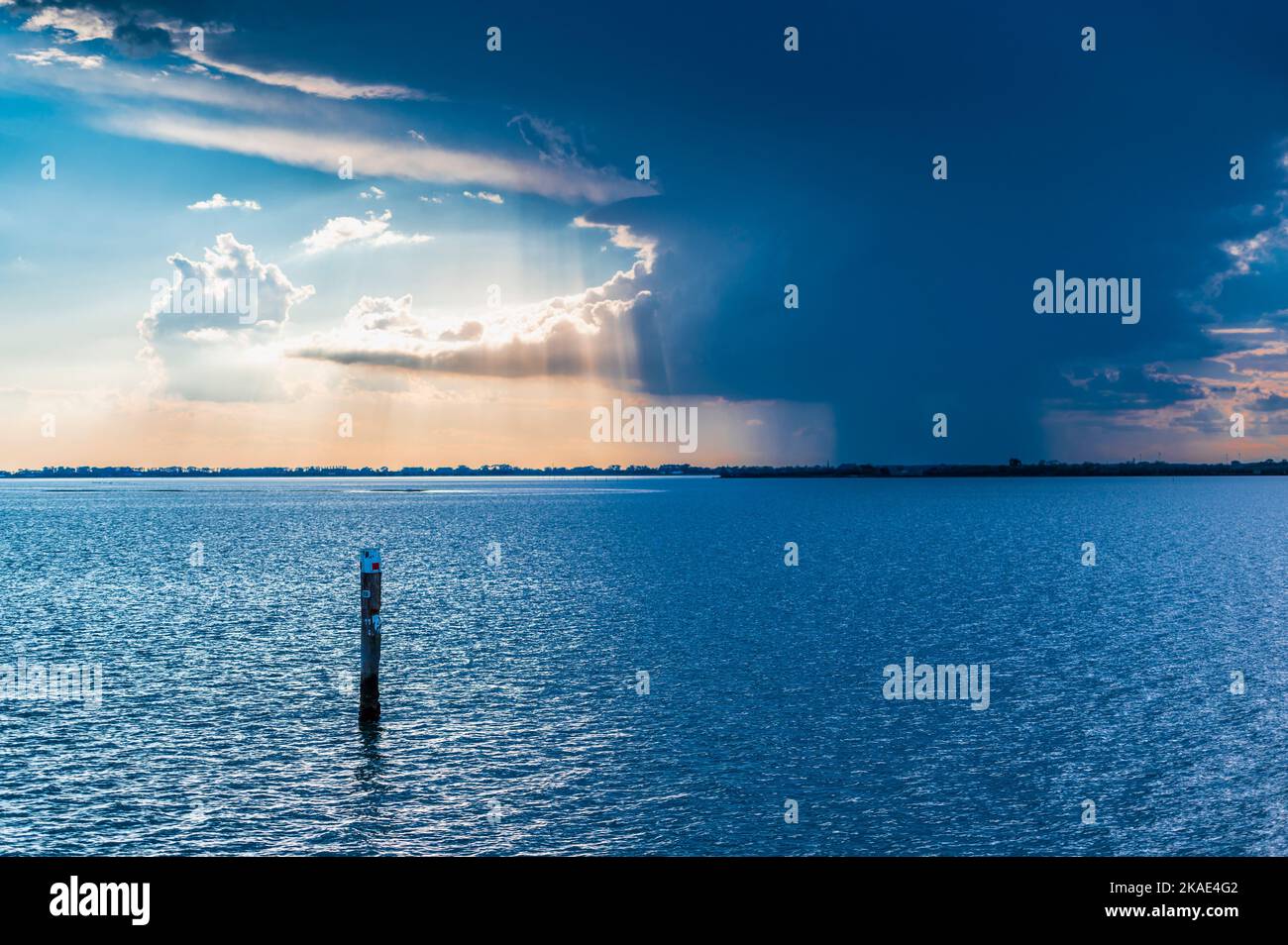Towards the sunset. Marano lagoon late summer colors. Clouds and sun ...