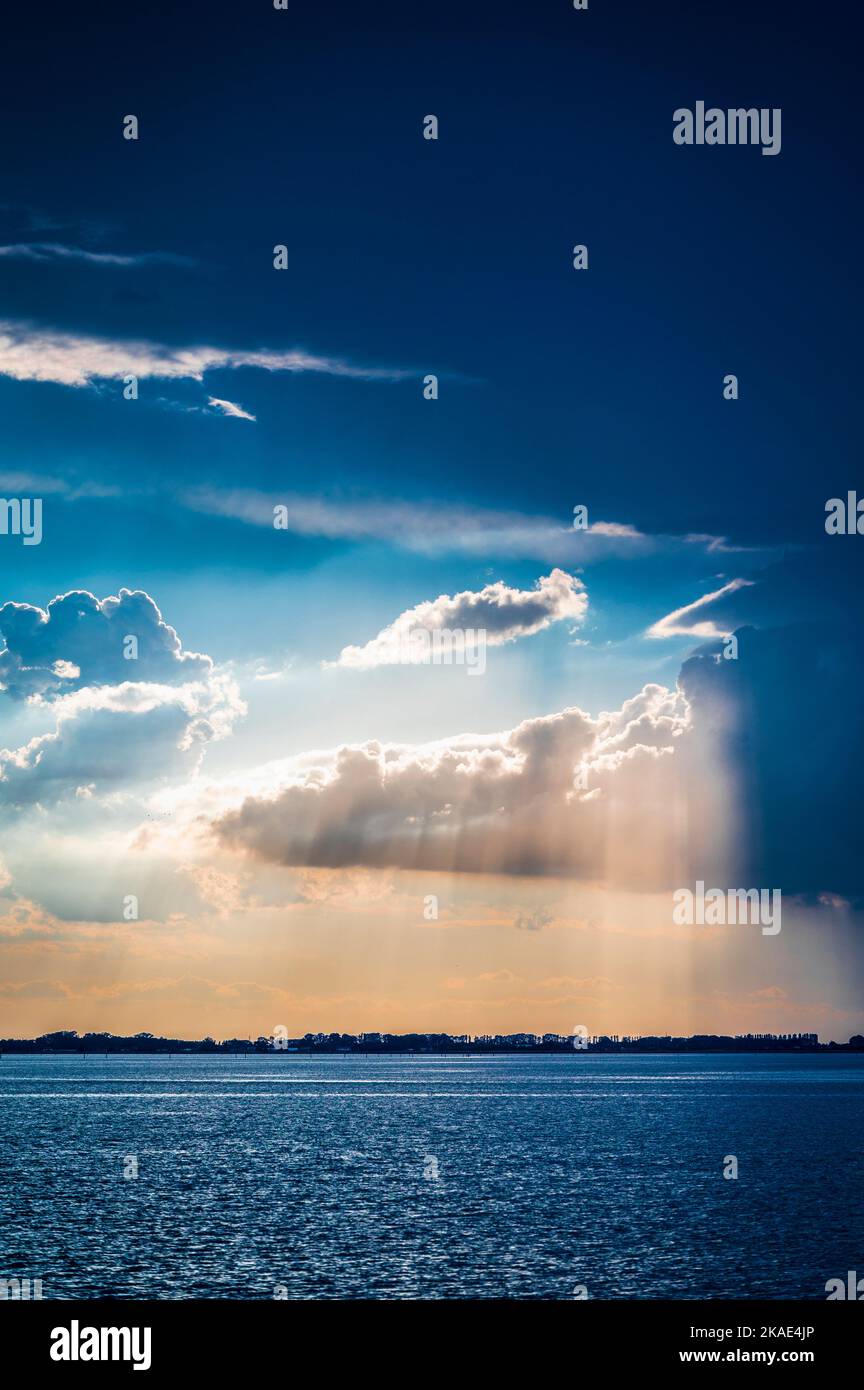 Towards the sunset. Marano lagoon late summer colors. Clouds and sun ...