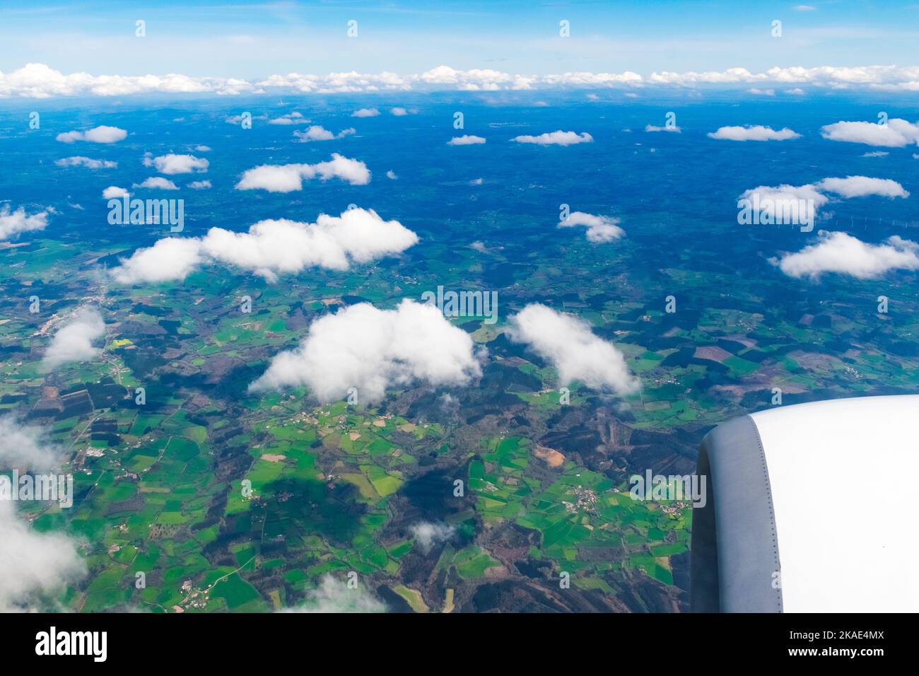 View through the airplane window of a sky with clouds, cropland and ...