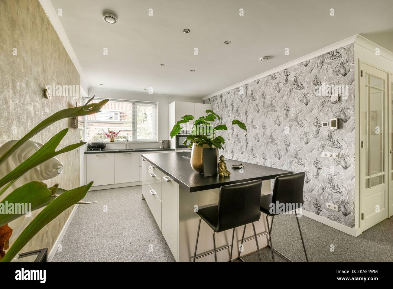 Table with chairs and flowers located near lounge area and kitchen in ...