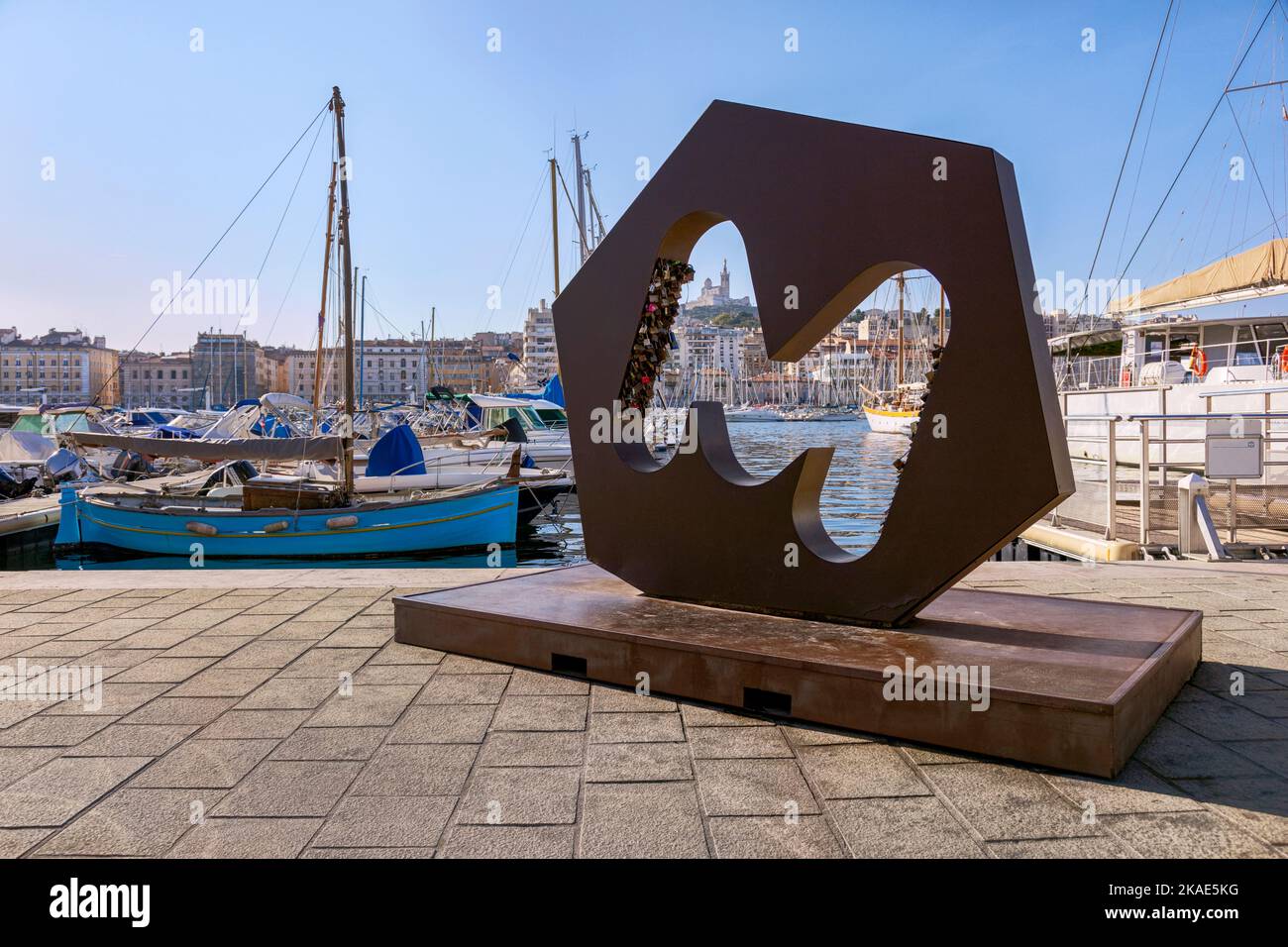 The letter M on the wharf of the Old Port with love locks, boats moored ...