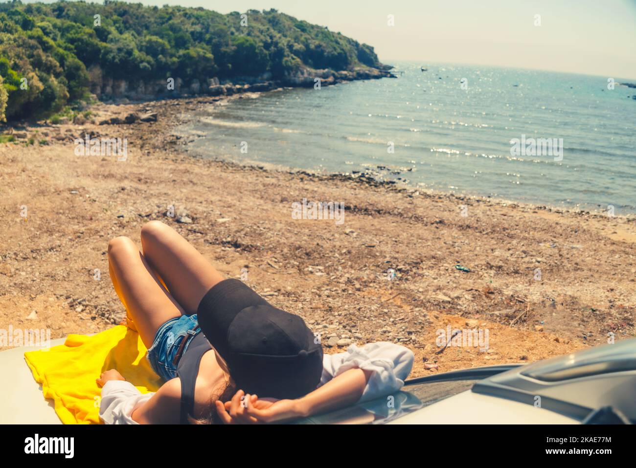 happy woman at sea summer beach sitting at car hood Stock Photo - Alamy