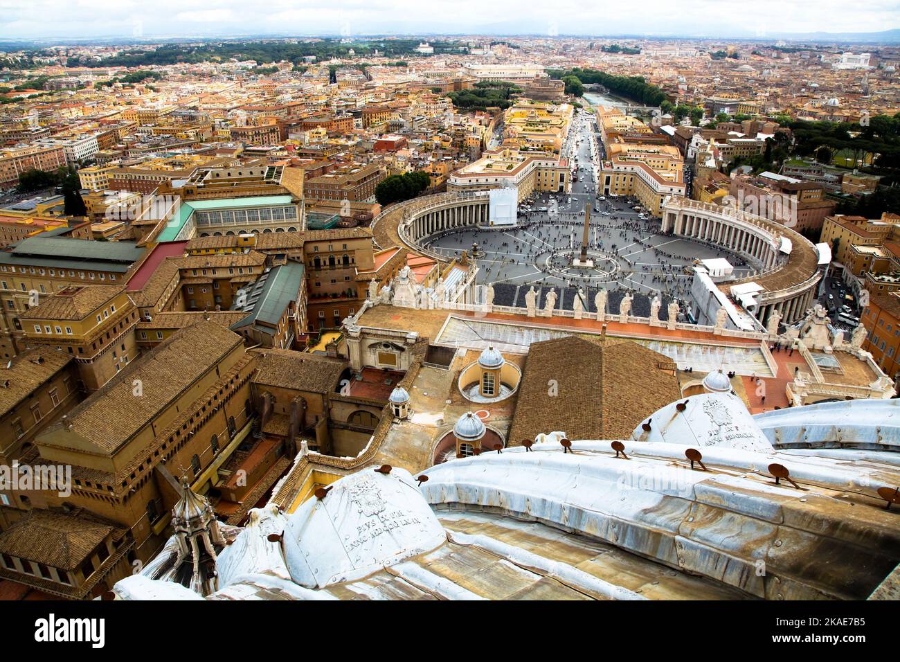A scenic view of St. Peter's square surrounded by dense buildings, Rome ...