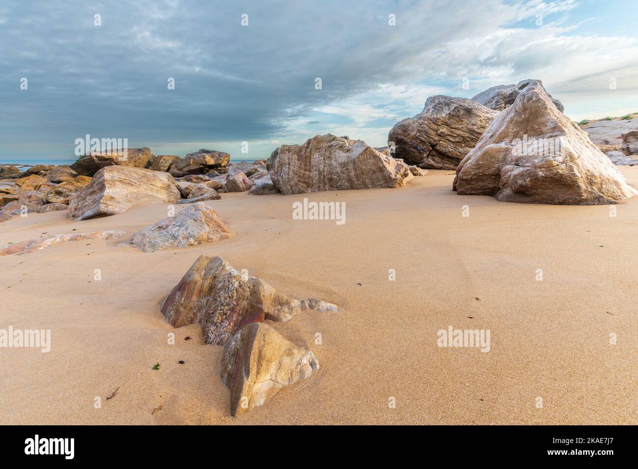Rocks polished by waves of Atlantic Ocean on sandy beach. Sables d ...
