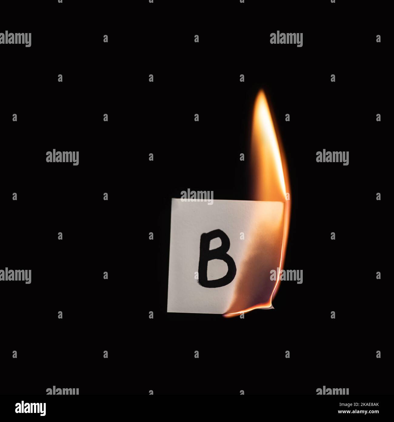 A small paper with letter B burning on a black background Stock Photo ...