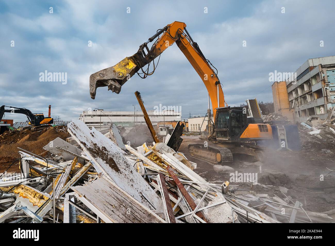 Excavator with hydraulic press breaks concrete leftovers Stock Photo - Alamy