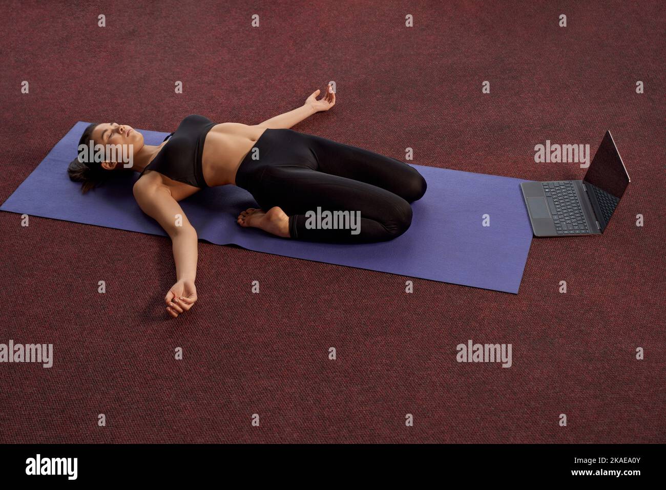 Above view of flexible girl practicing yoga pose on yoga mat. Young ...