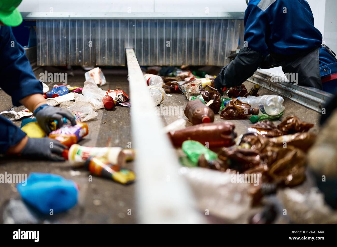 Worker sorts trash on conveyor belt at waste recycling plant Stock Photo - Alamy