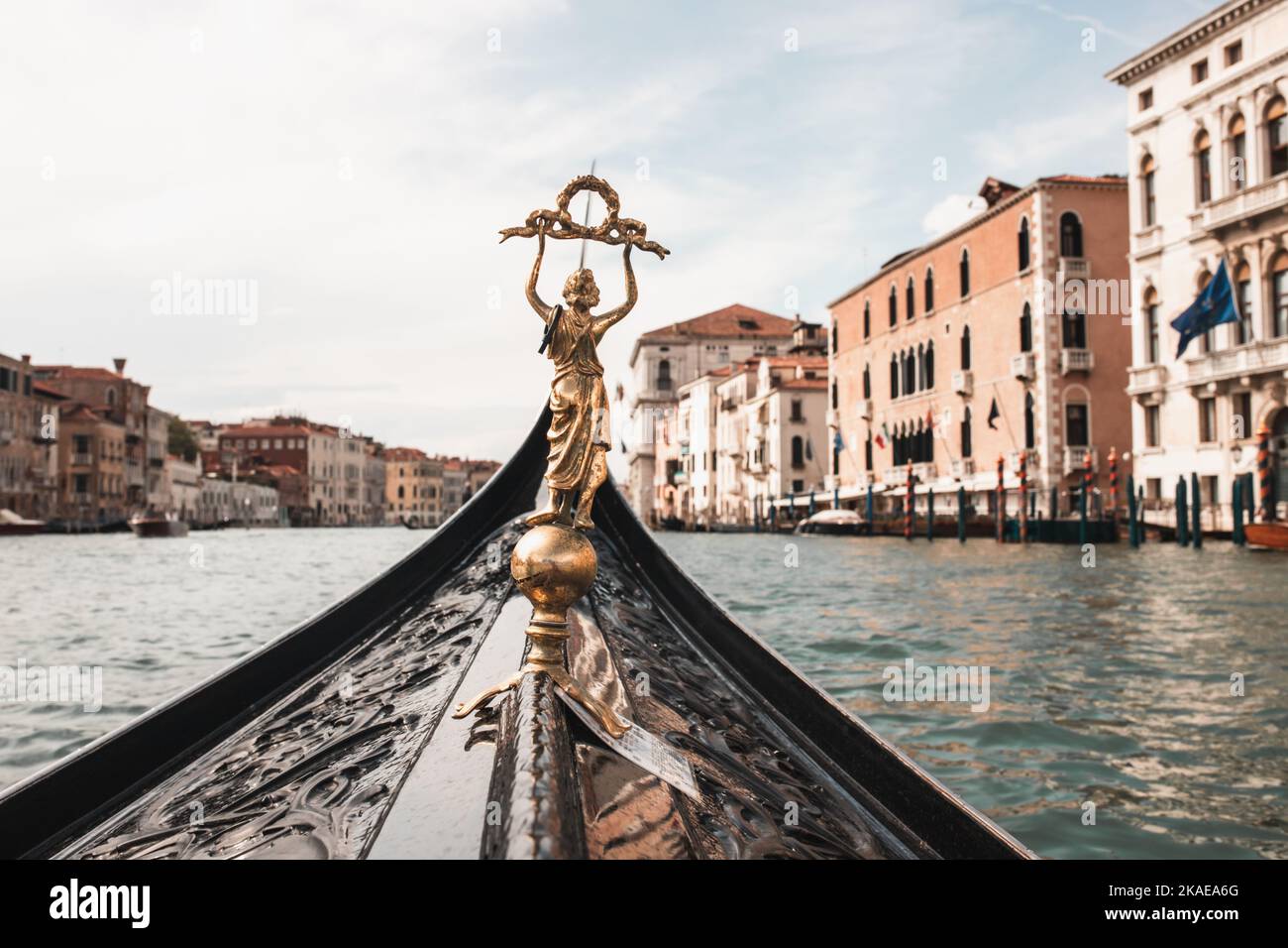 The front of a boat with a decorative figure on waterscape surrounded ...