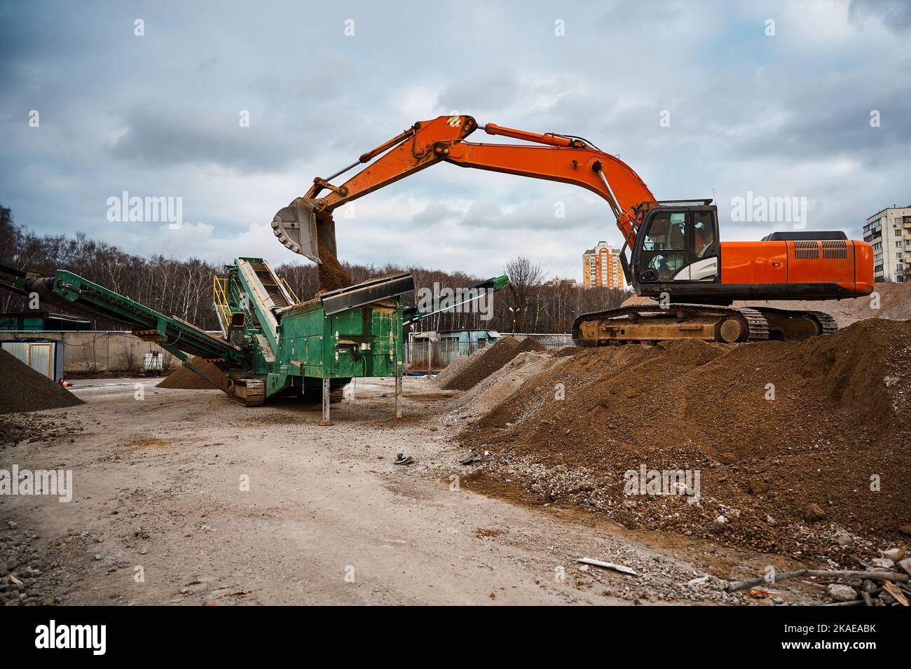 Excavator loads soil in mobile crushing and sorting complex Stock Photo ...