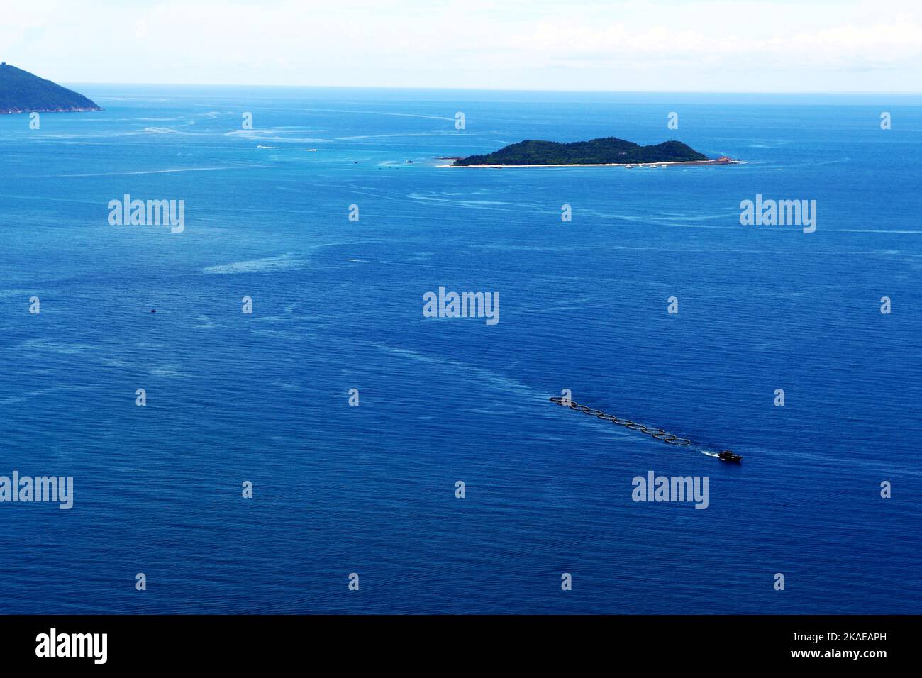 An aerial view of a beautiful seascape with a small island and a boat ...