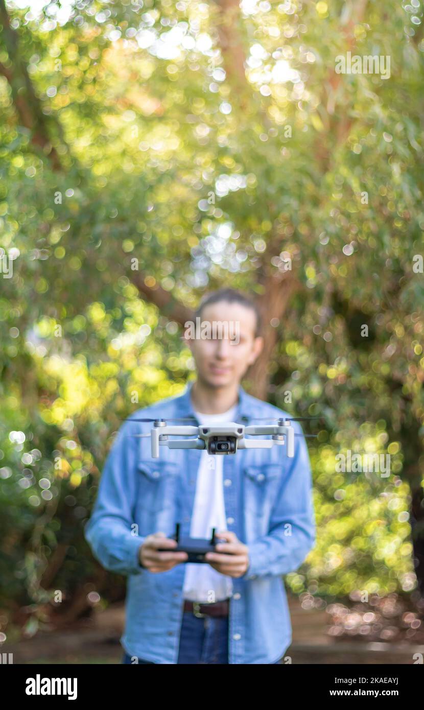 Vertical view of young blurred man with drone in the front in selective ...