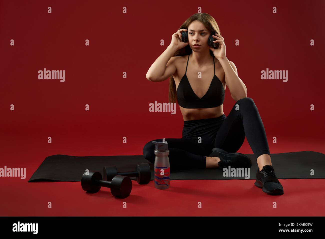 Beautiful brunette woman resting after training with dumbbells and ...