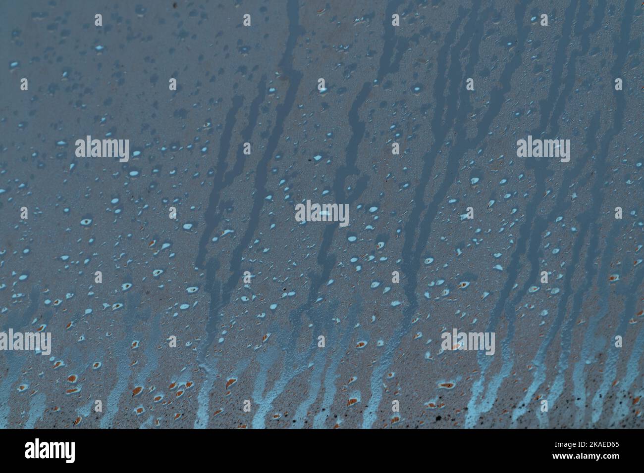 Many Raindrops and streams of rain on a window with blue and grey ...