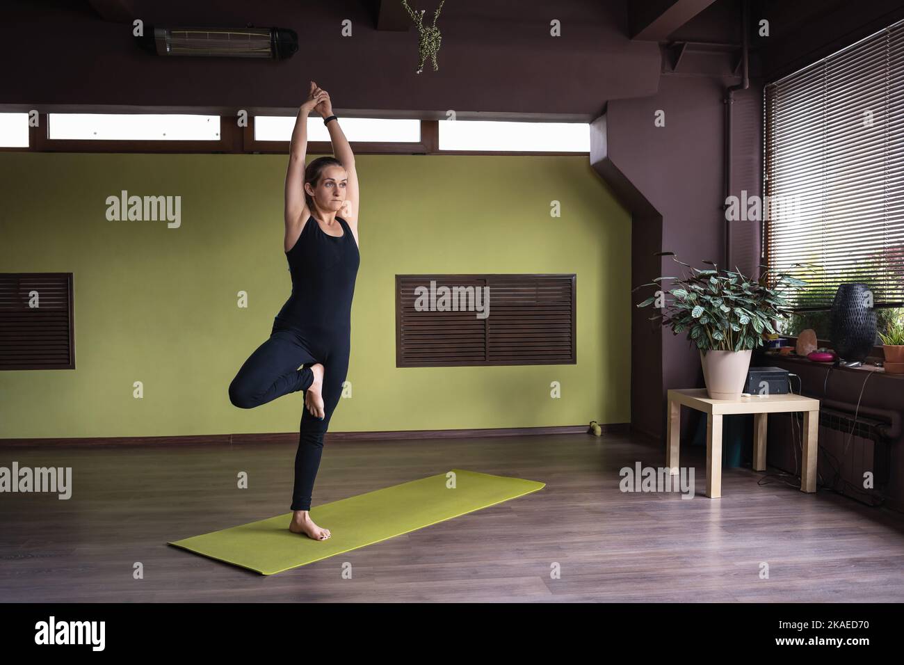 A woman leading a healthy lifestyle and practicing yoga, performs the ...