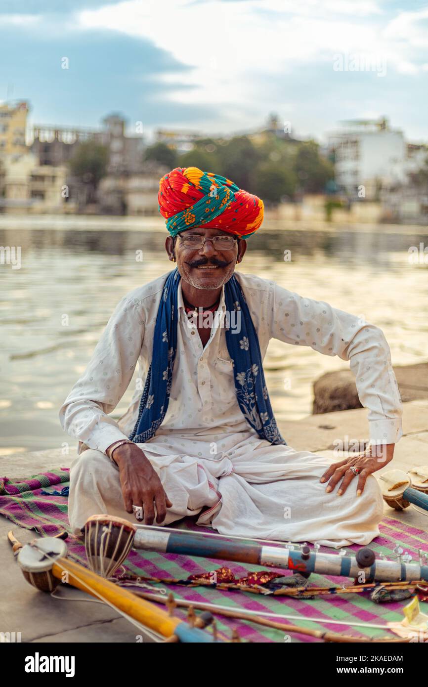 A Rajasthani man sitting on a shore with a musical instrument Stock ...